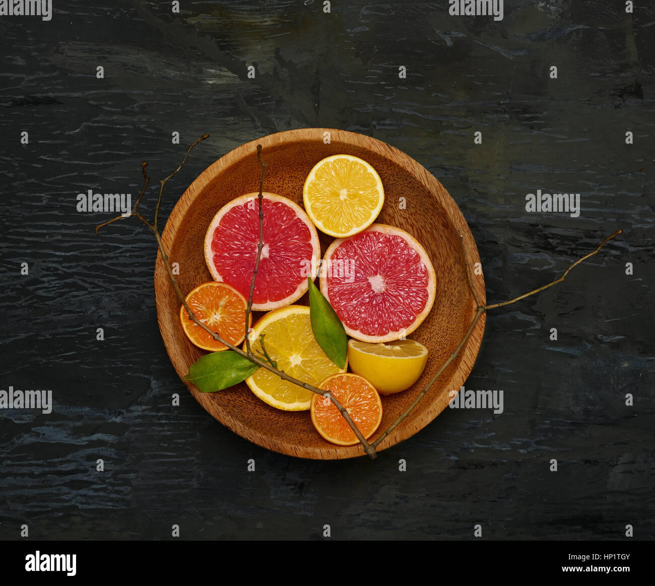 Grapefruit citrus fruit halves on wooden plate Stock Photo - Alamy