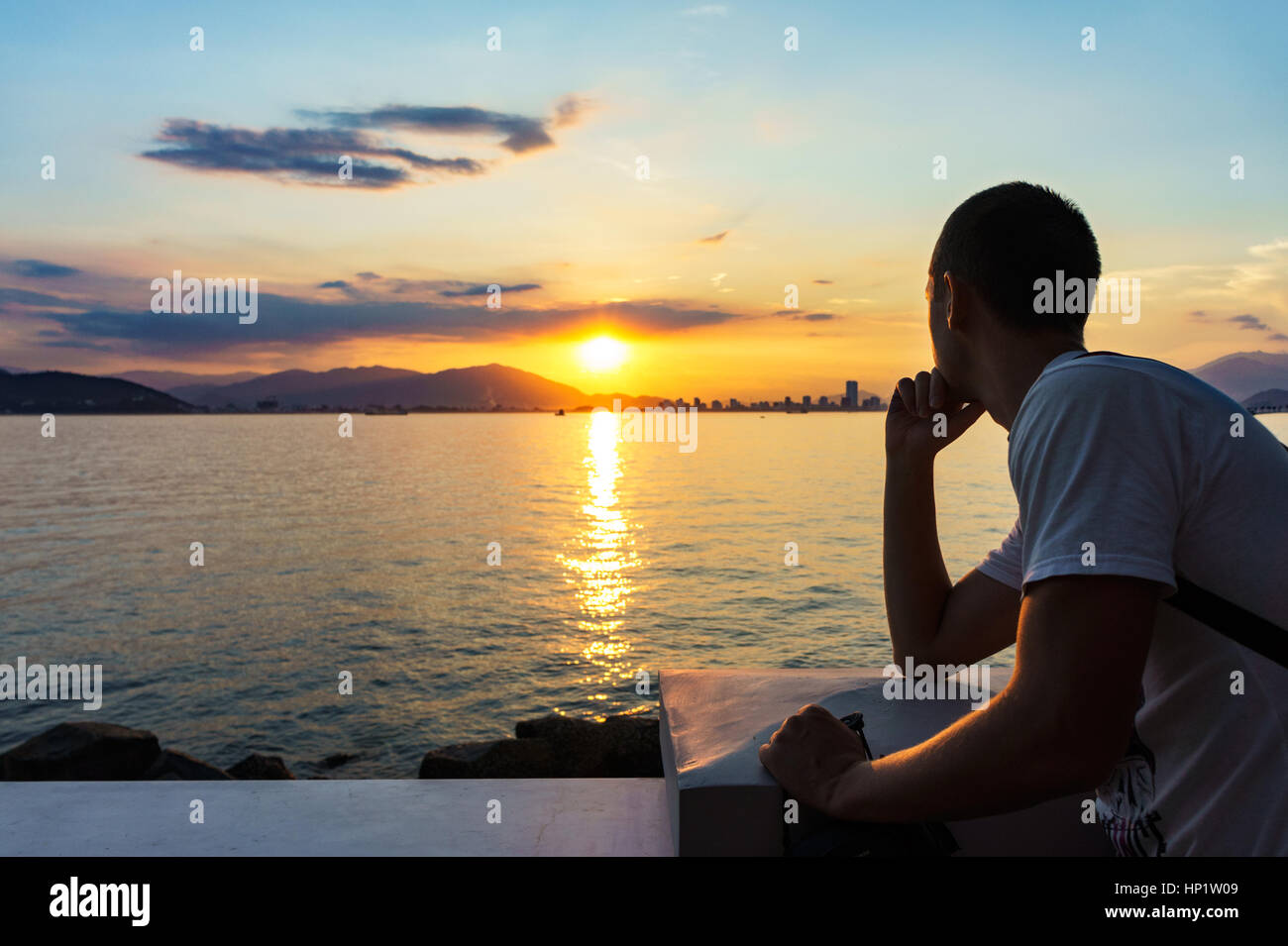 Young man is looking at the sunrise Stock Photo - Alamy