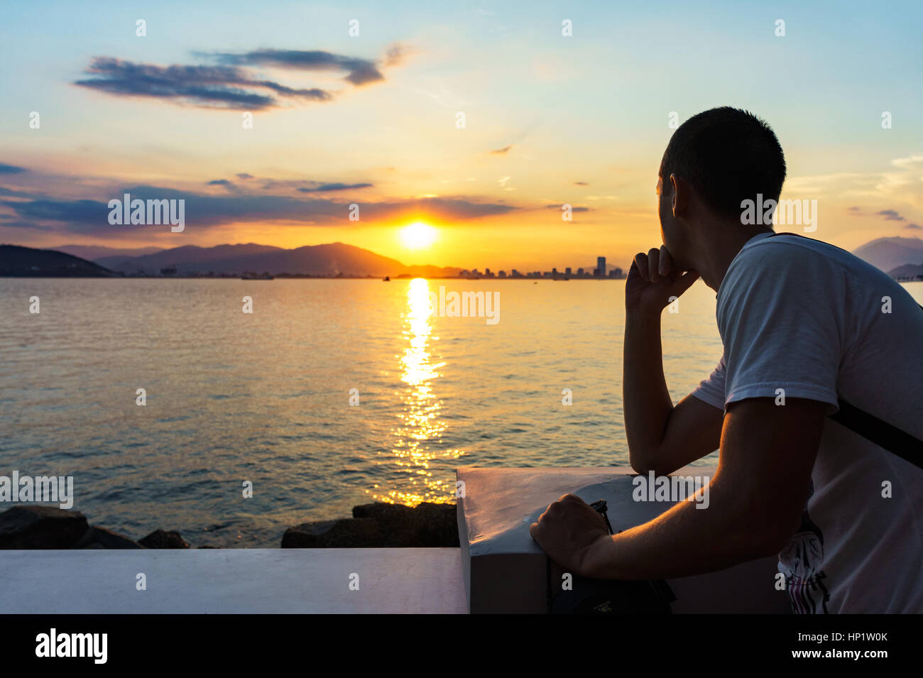 Young man is looking at the sunrise Stock Photo - Alamy