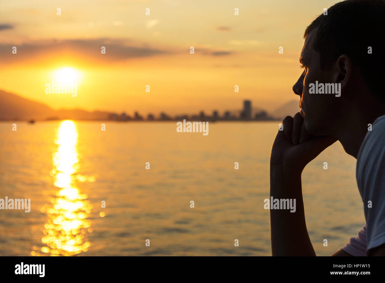 Young man is looking at the sunrise Stock Photo - Alamy