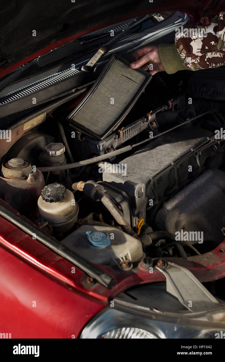 The mechanic pulls out the old air filter. Replacing the air filter in ...