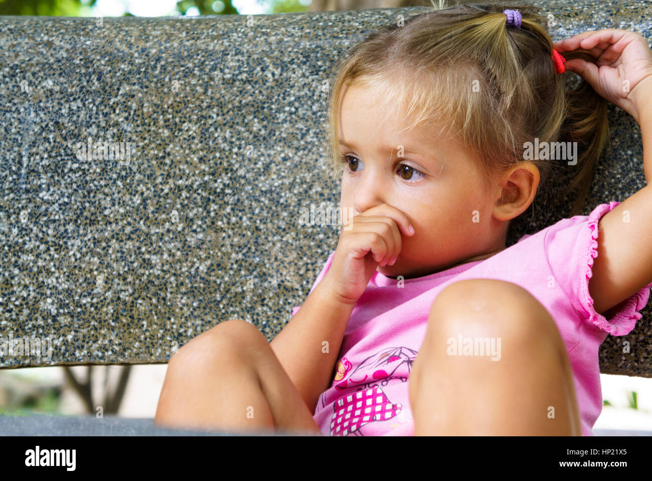 little girl sitting on the bench in park Stock Photo - Alamy