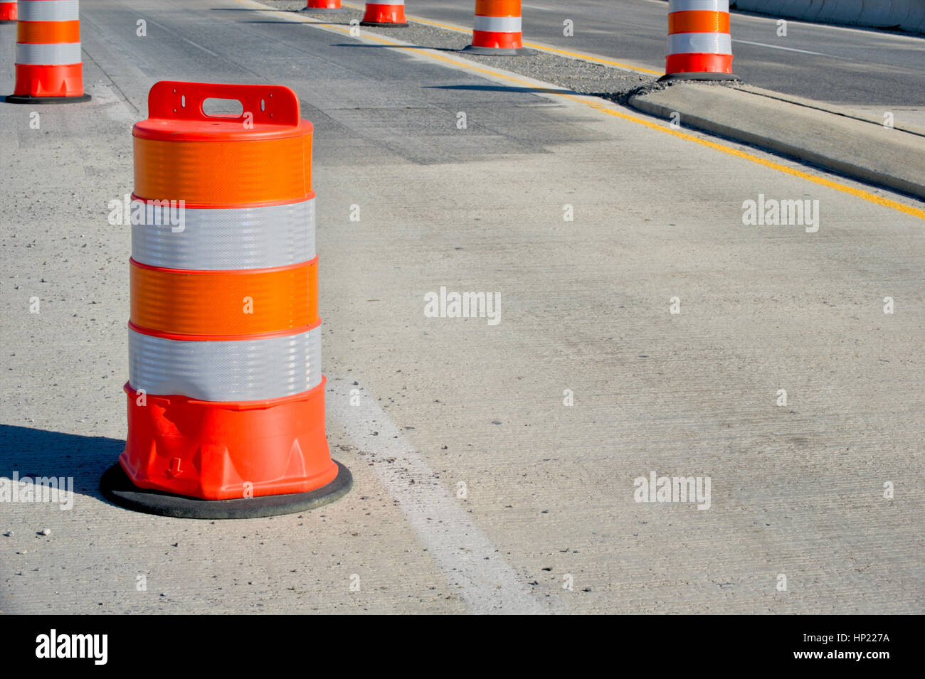 Orange and white reflective delineator posts channels traffic in order ...