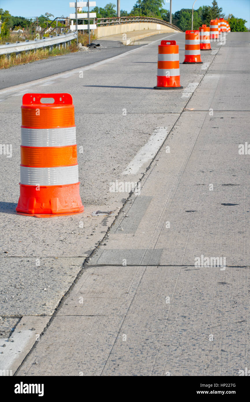 Orange and white reflective delineator posts channels traffic in order ...