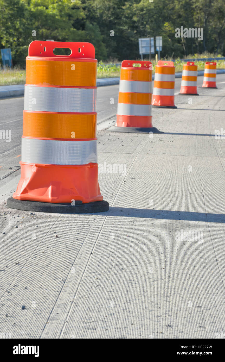 Orange and white reflective delineator posts channels traffic in order ...