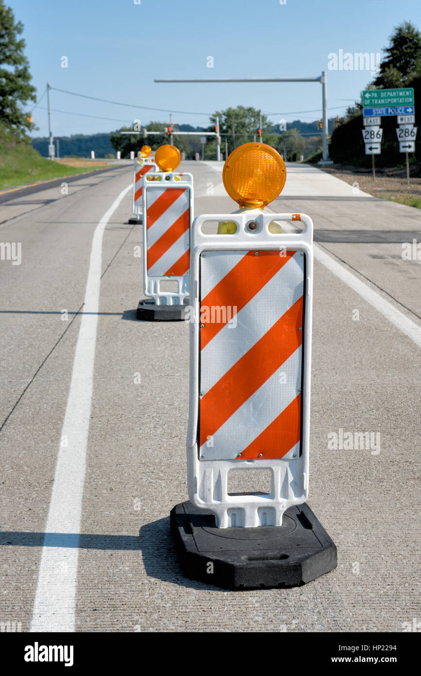 Orange and white reflective delineator posts channels traffic in order ...