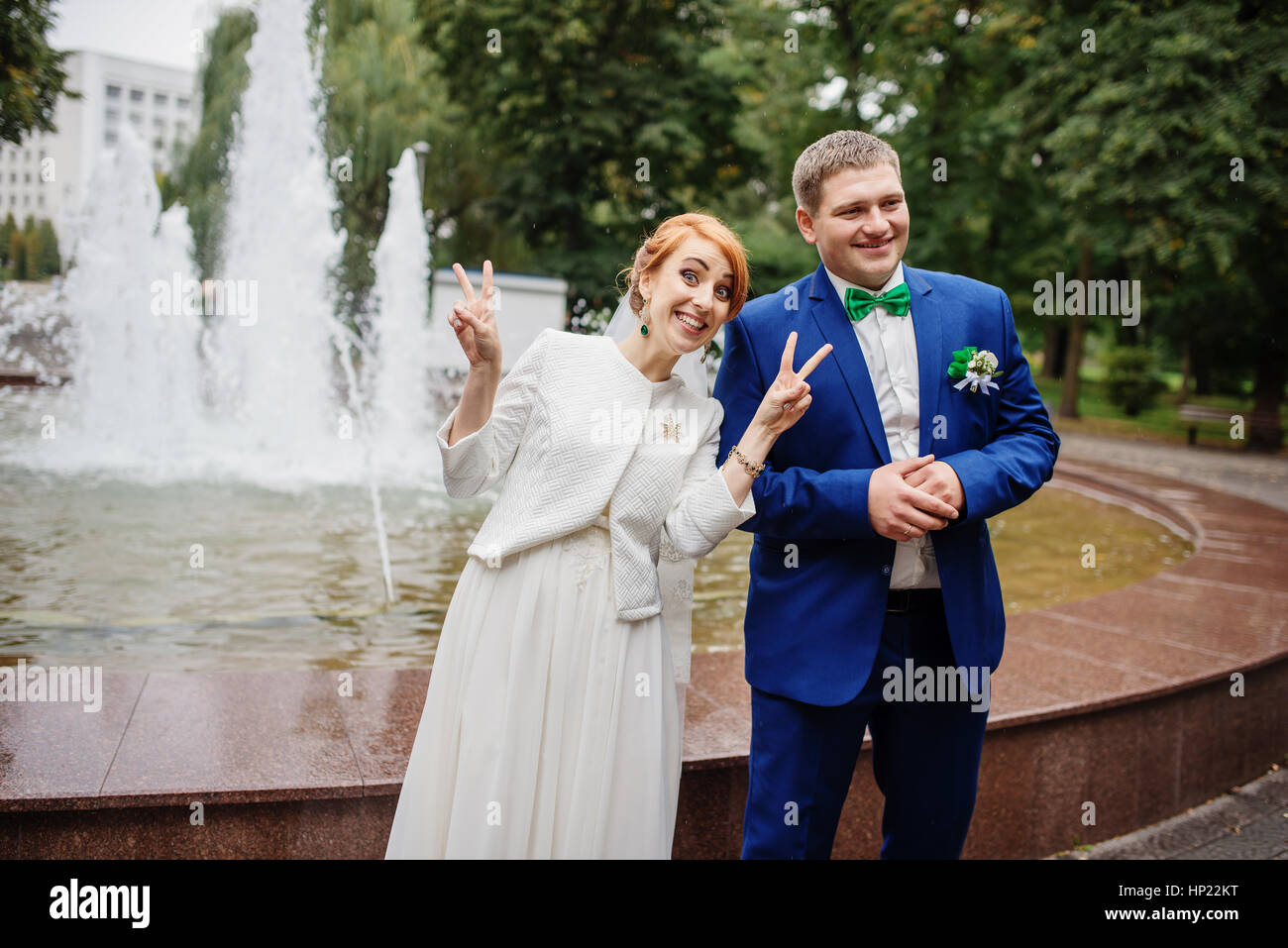 Funny wedding couple having fun background fountain Stock Photo - Alamy