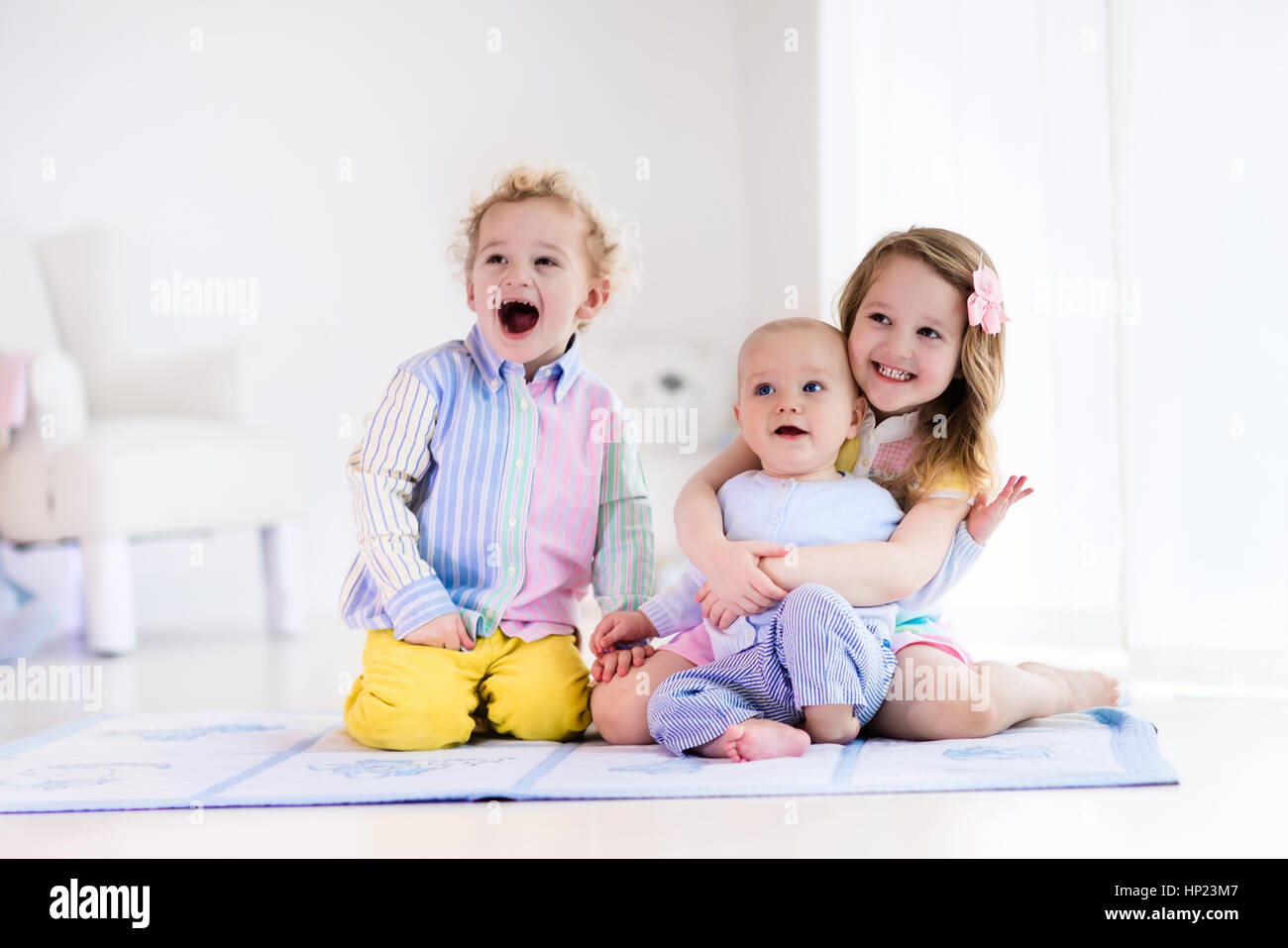 Group of three kids playing in a white bedroom. Children play at home ...