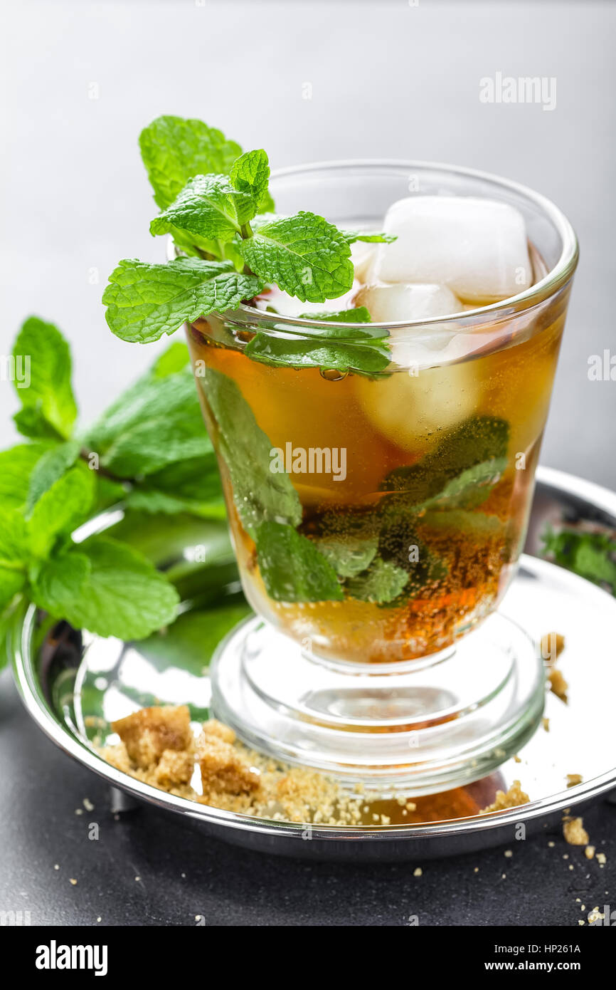 Mint Julep cocktail with bourbon, ice and mint in glass on black ...
