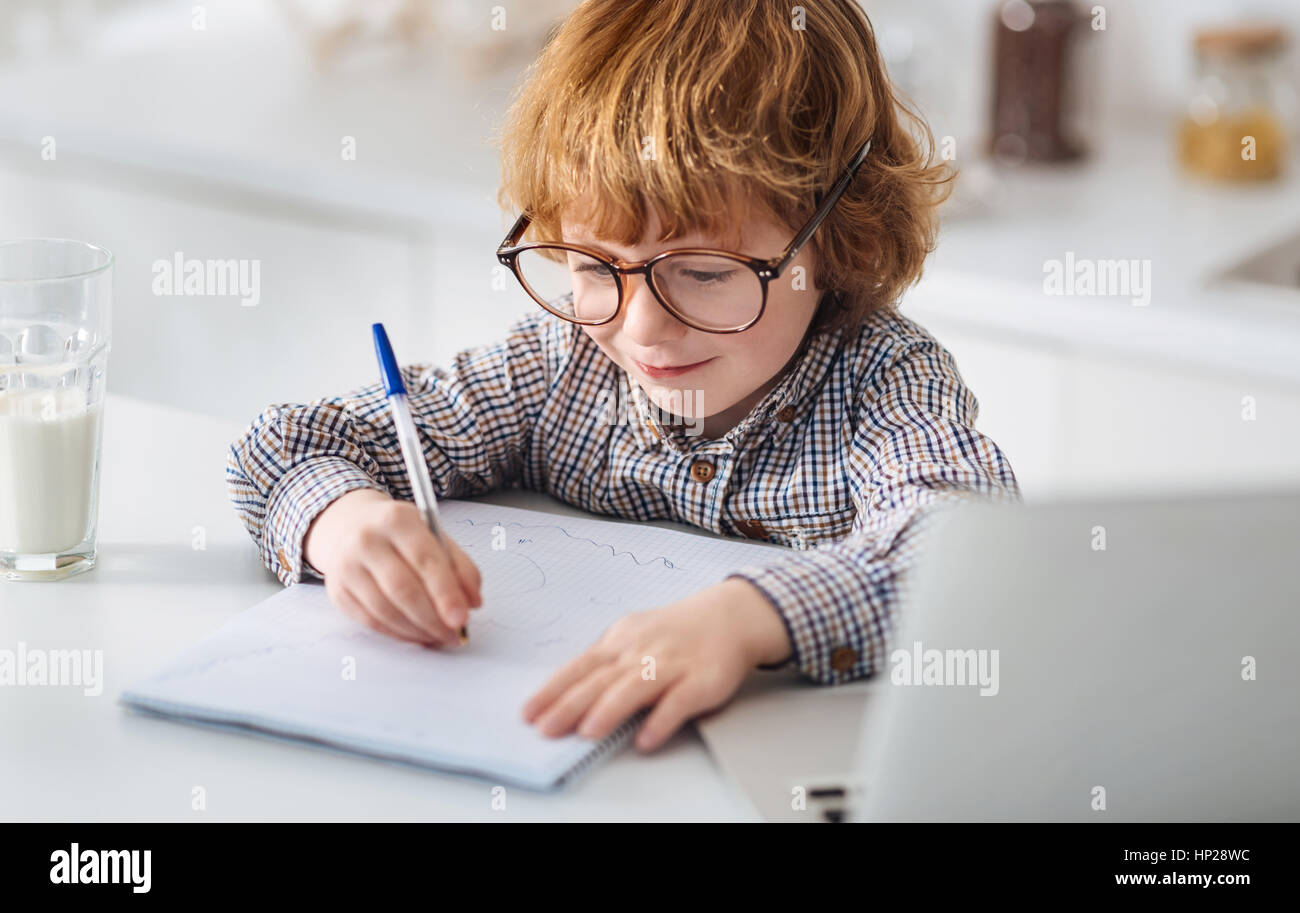 Clever boy doing his home assignment Stock Photo - Alamy