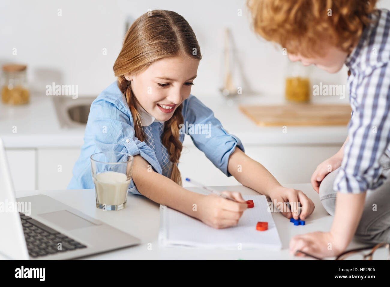Happy smart girl doing homework with her brother Stock Photo - Alamy
