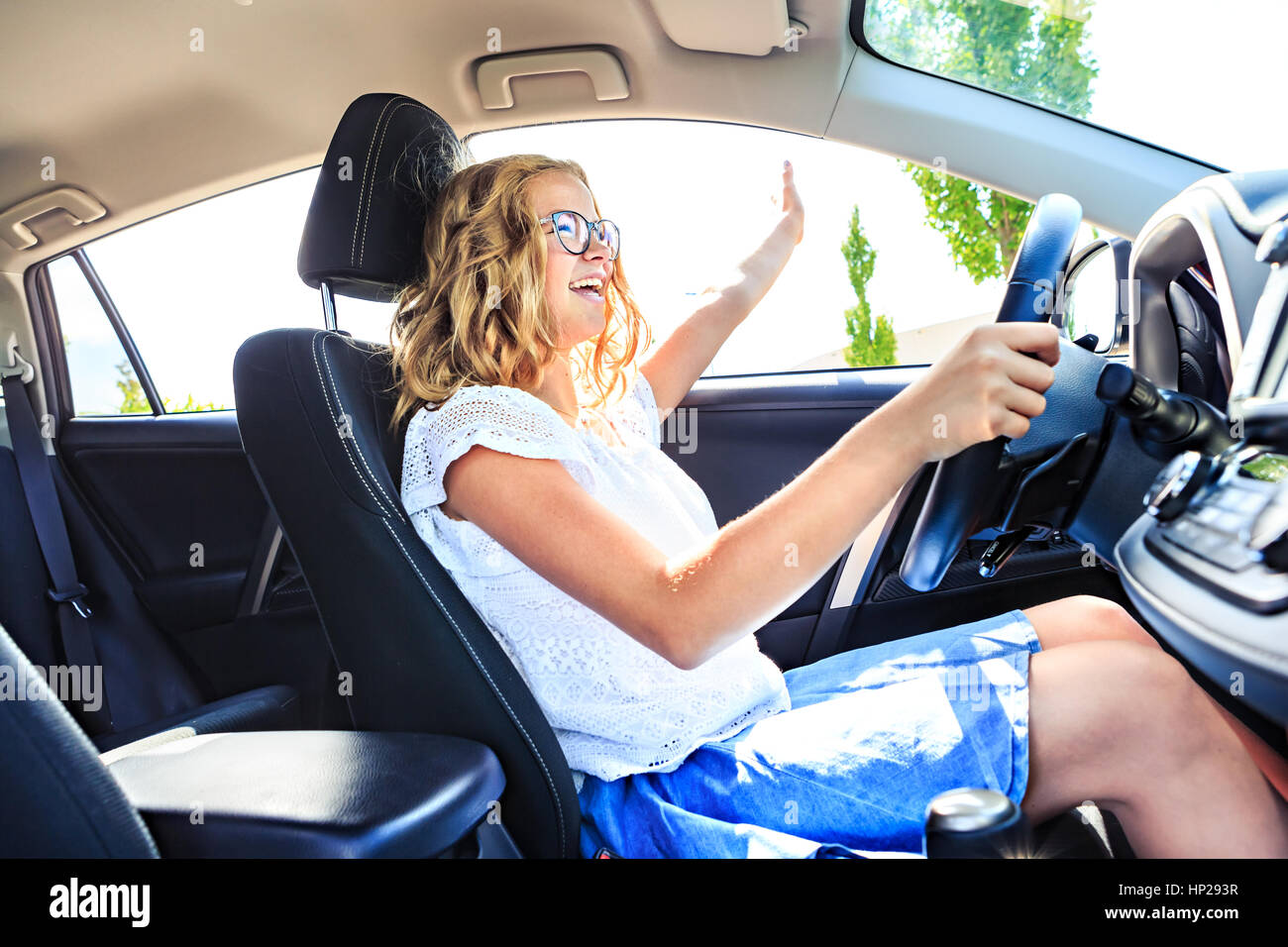 a young girl driving a car in the town Stock Photo - Alamy