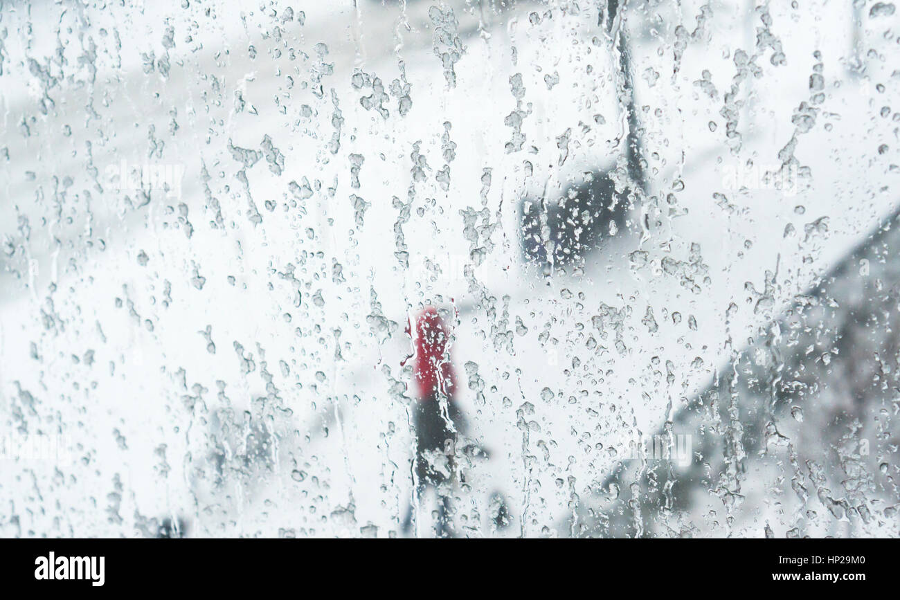 Intrepid pedestrians slough through the snow, seen through an ice ...