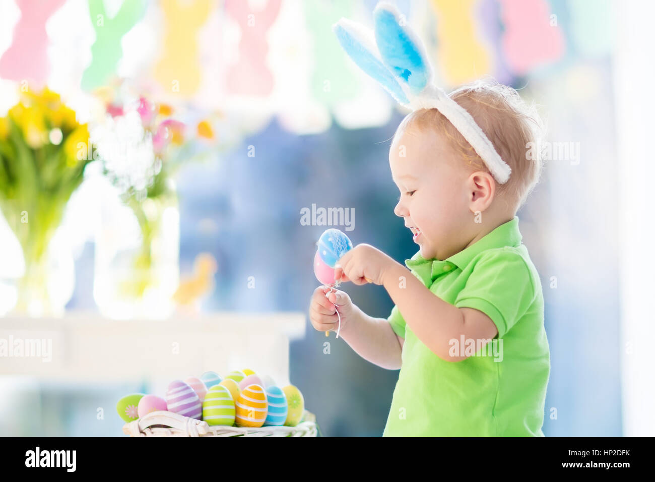 Kids celebrate Easter. Funny happy baby in bunny ears playing with ...