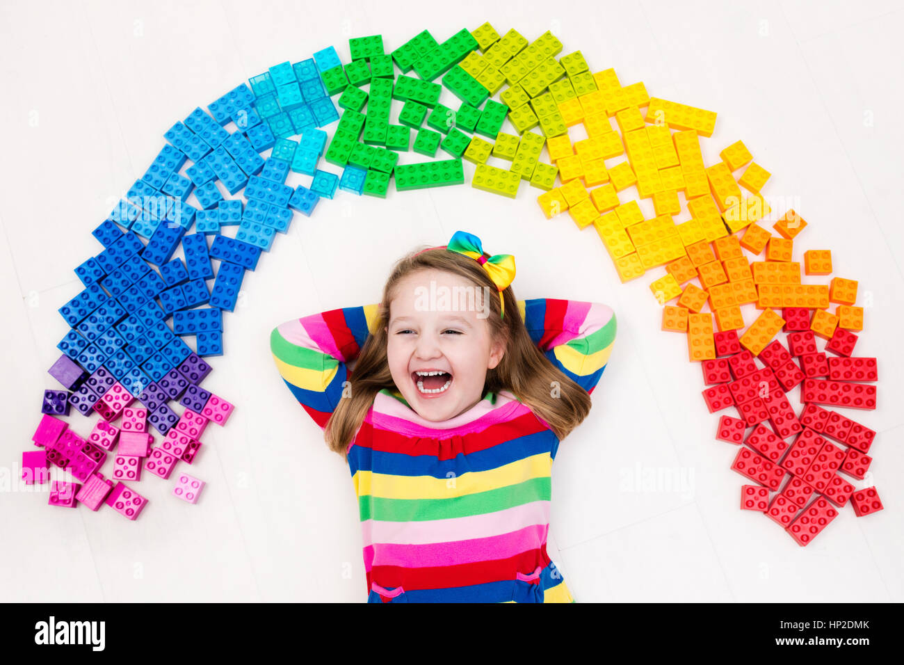 Funny little girl playing with colorful rainbow plastic blocks. Kids ...