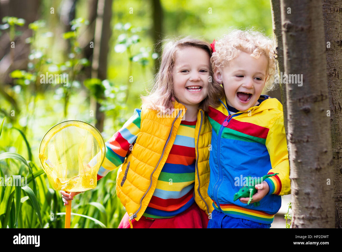 Children playing outdoors. Preschool kids catching frog with net. Boy ...