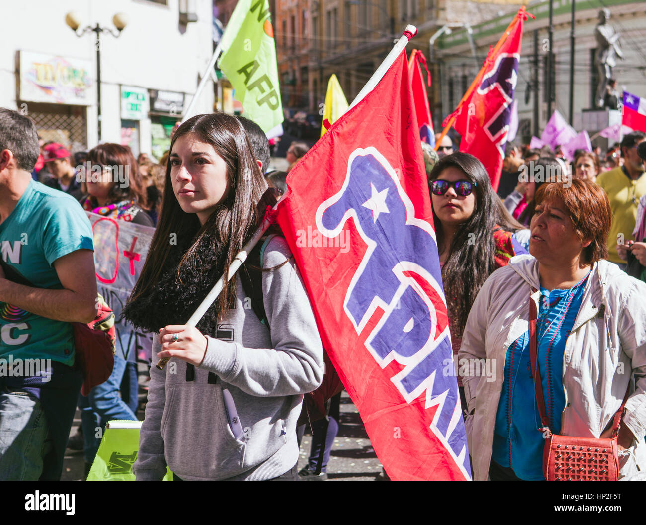 A young woman carries a FPMR flag, "Frente Patriotico Manuel Rodriguez ...