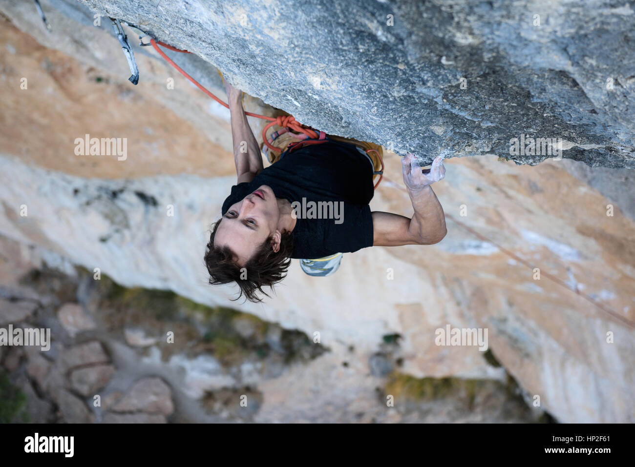 Rock climber ascending a challenging cliff. Extreme sport climbing ...