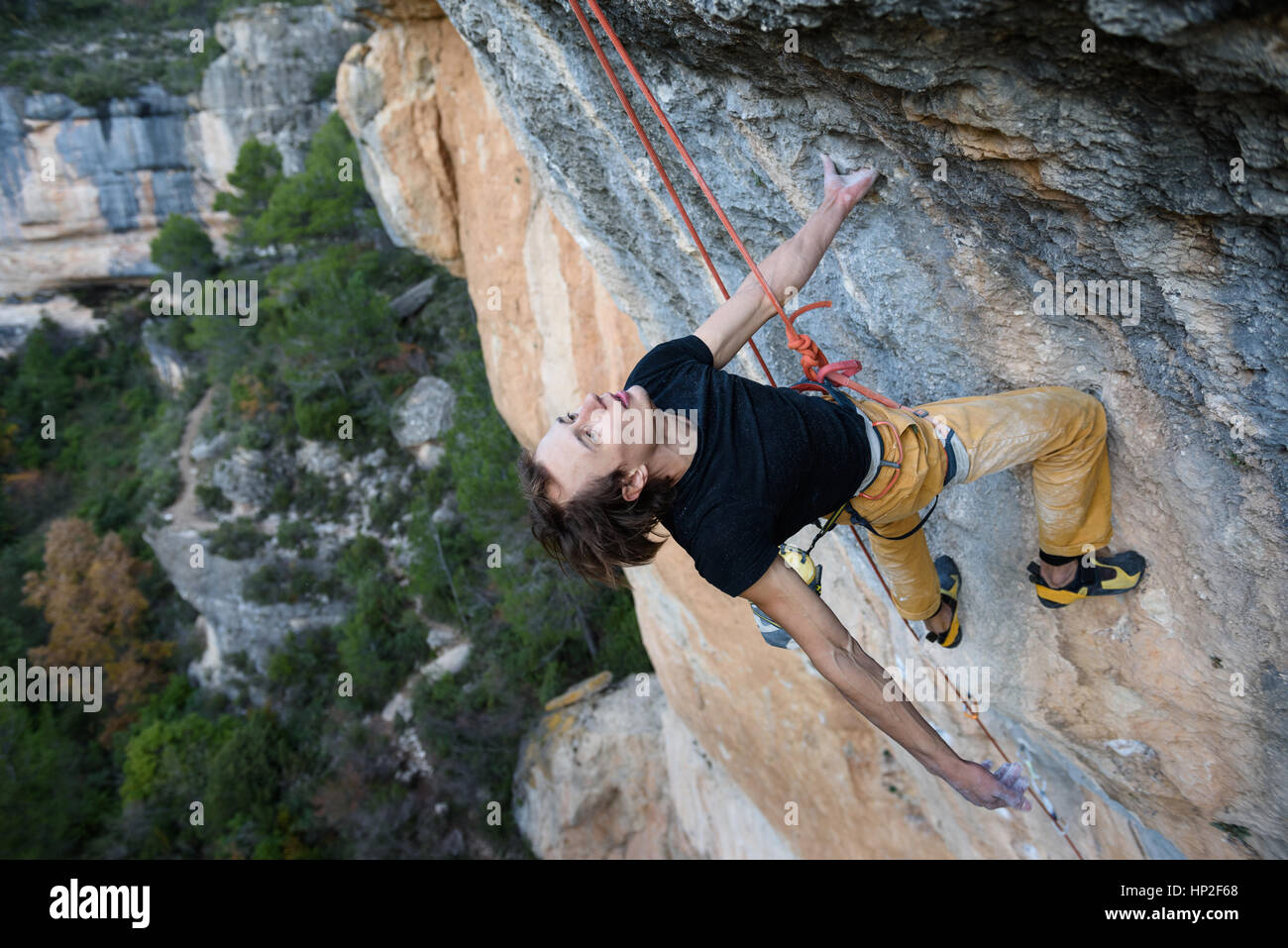 Rock climber ascending a challenging cliff. Extreme sport climbing ...