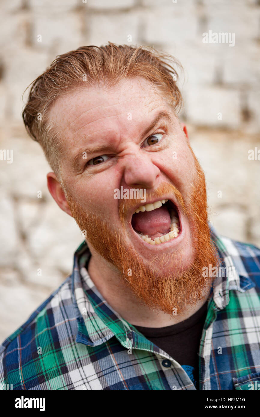 Portrait of red haired hipster man with blue plaid shirt expressing a ...