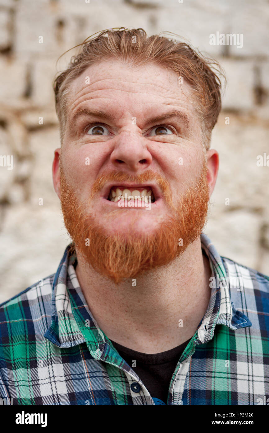 Portrait of red haired hipster man with blue plaid shirt expressing a ...
