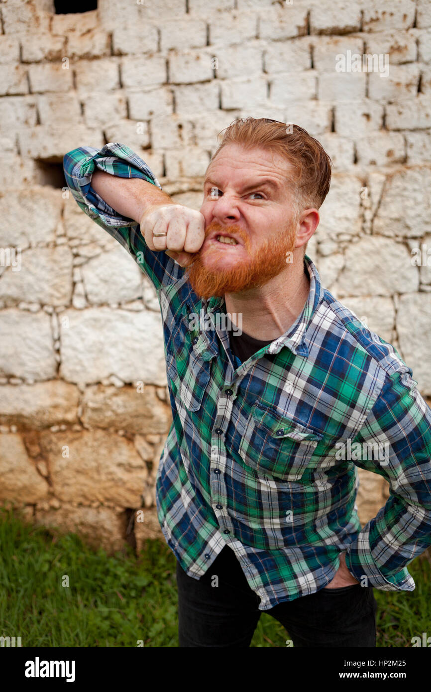 Portrait of red haired hipster man with blue plaid shirt expressing a ...