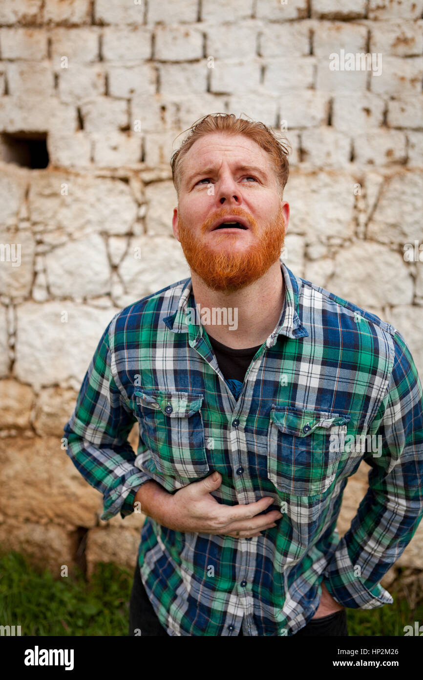 Portrait of red haired hipster man with blue plaid shirt expressing a ...