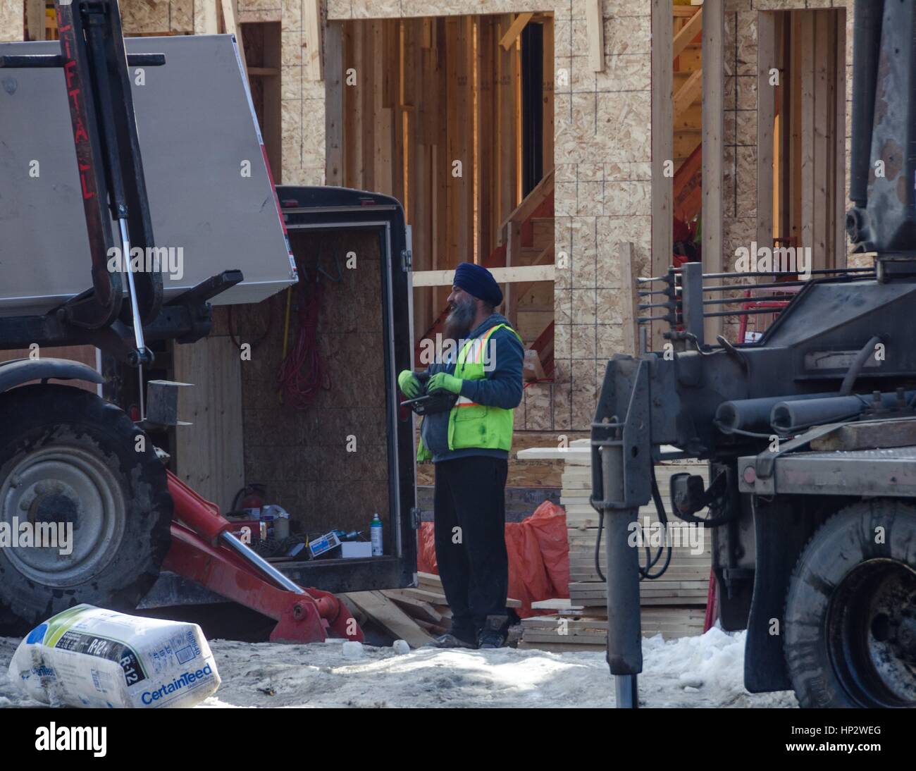 A construction worker operates a remote control forklift to load ...