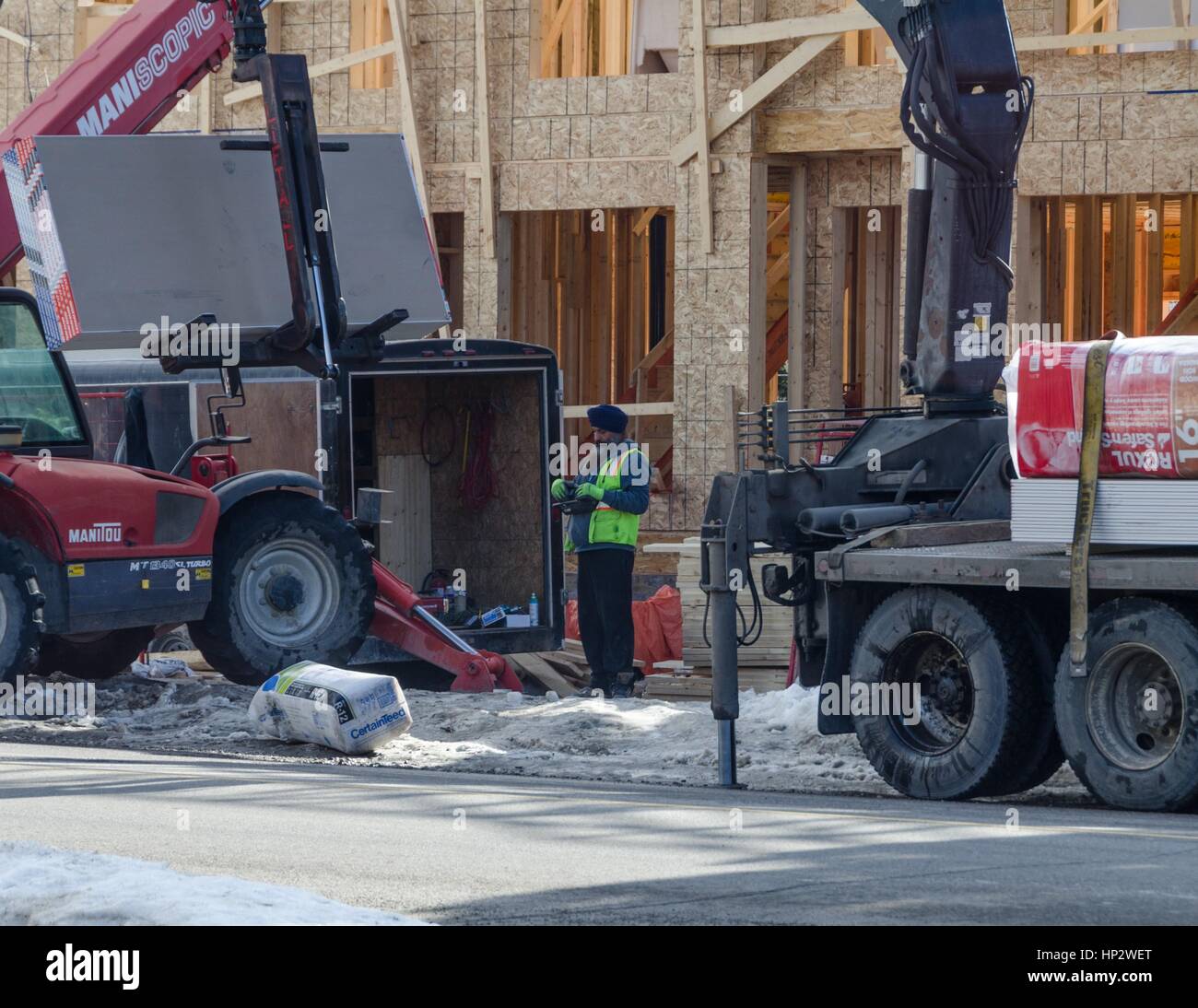A construction worker operates a remote control forklift to load ...