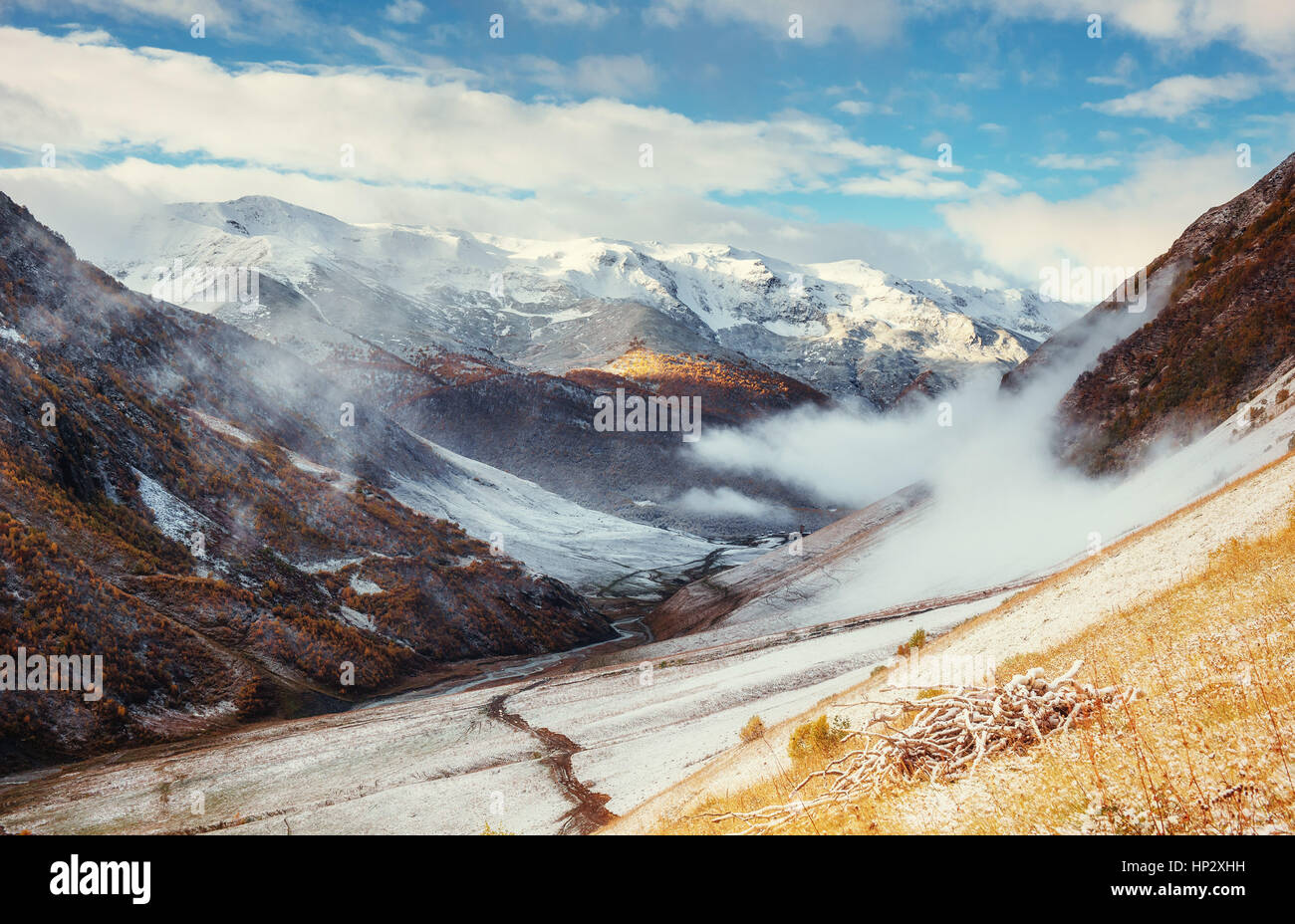 Mountain landscape of snow-capped mountains in the mist Stock Photo - Alamy