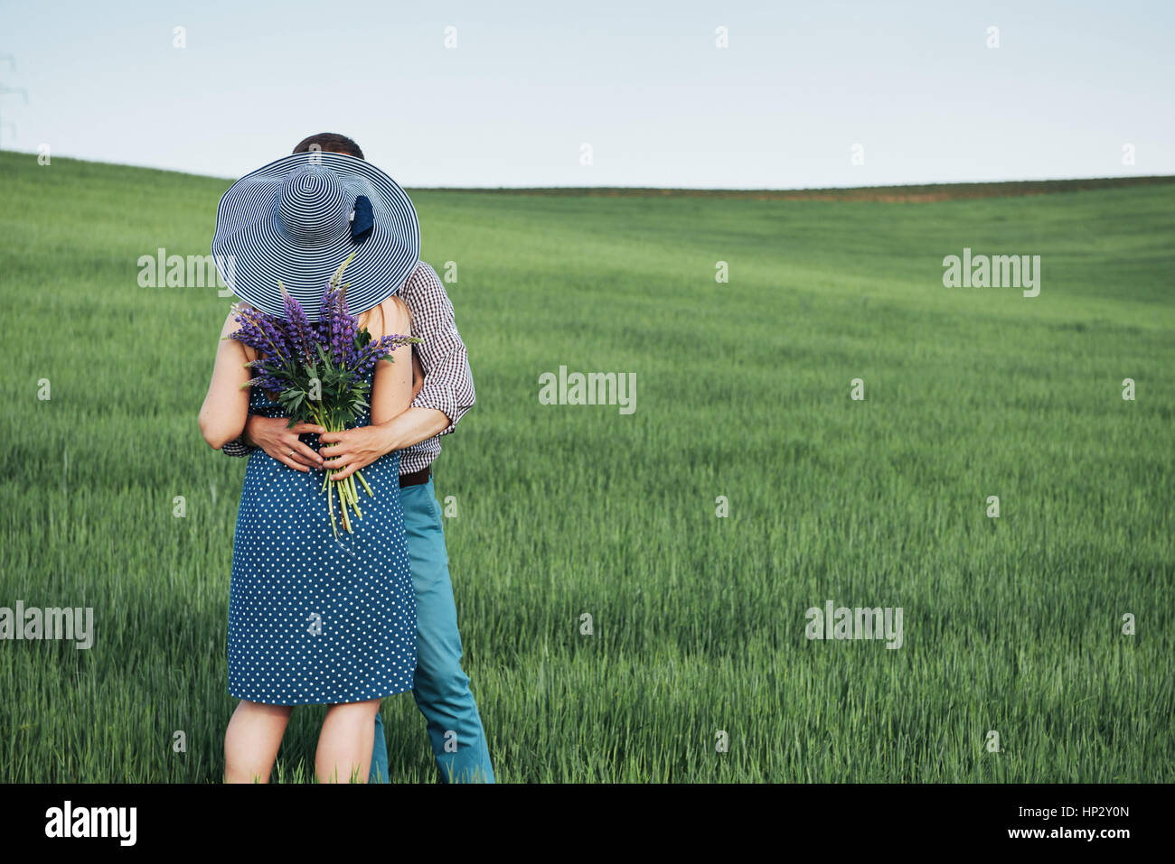 Happy family hugging in a field of green wheat Stock Photo - Alamy