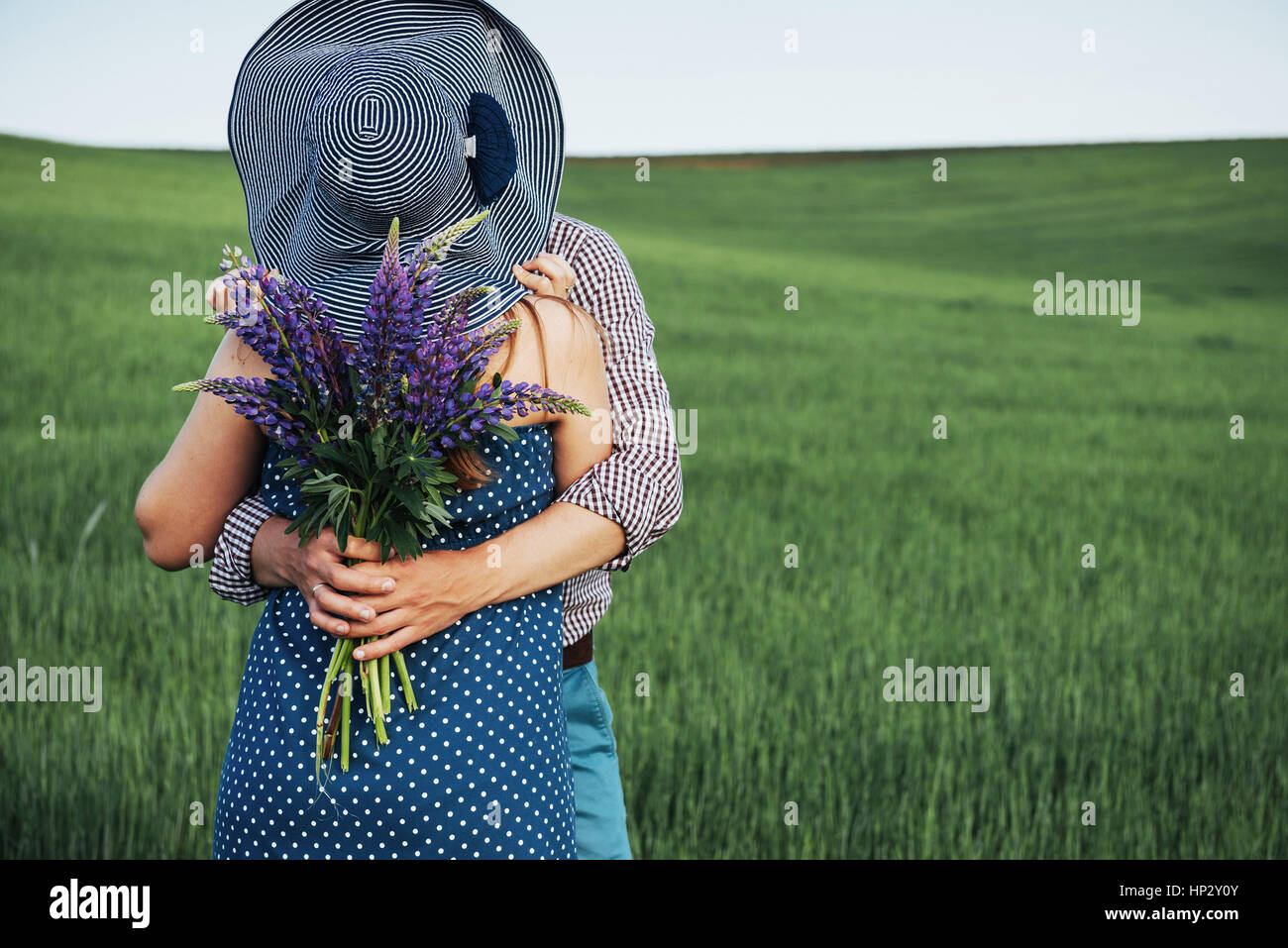Happy family hugging in a field of green wheat Stock Photo - Alamy