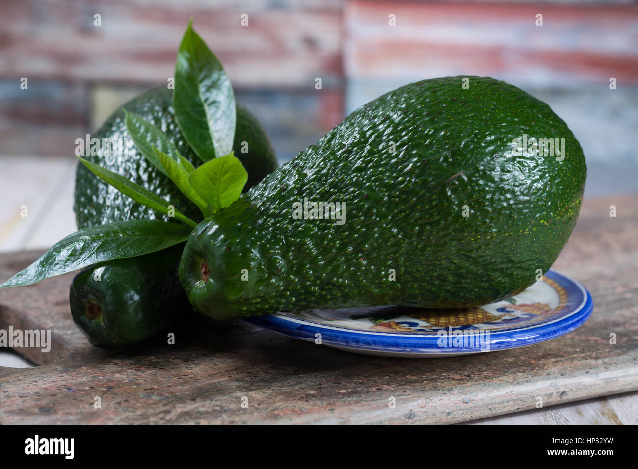 Green ripe fresh avocado with leaves on granite plank Stock Photo - Alamy