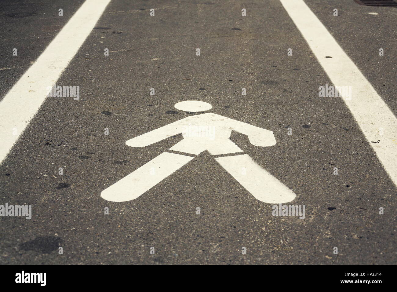 Walking man pedestrian sign painted white on concrete way Stock Photo ...