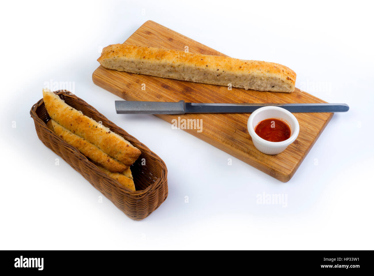 baked garlic bread cut in strips in a basket and cutting board Stock ...