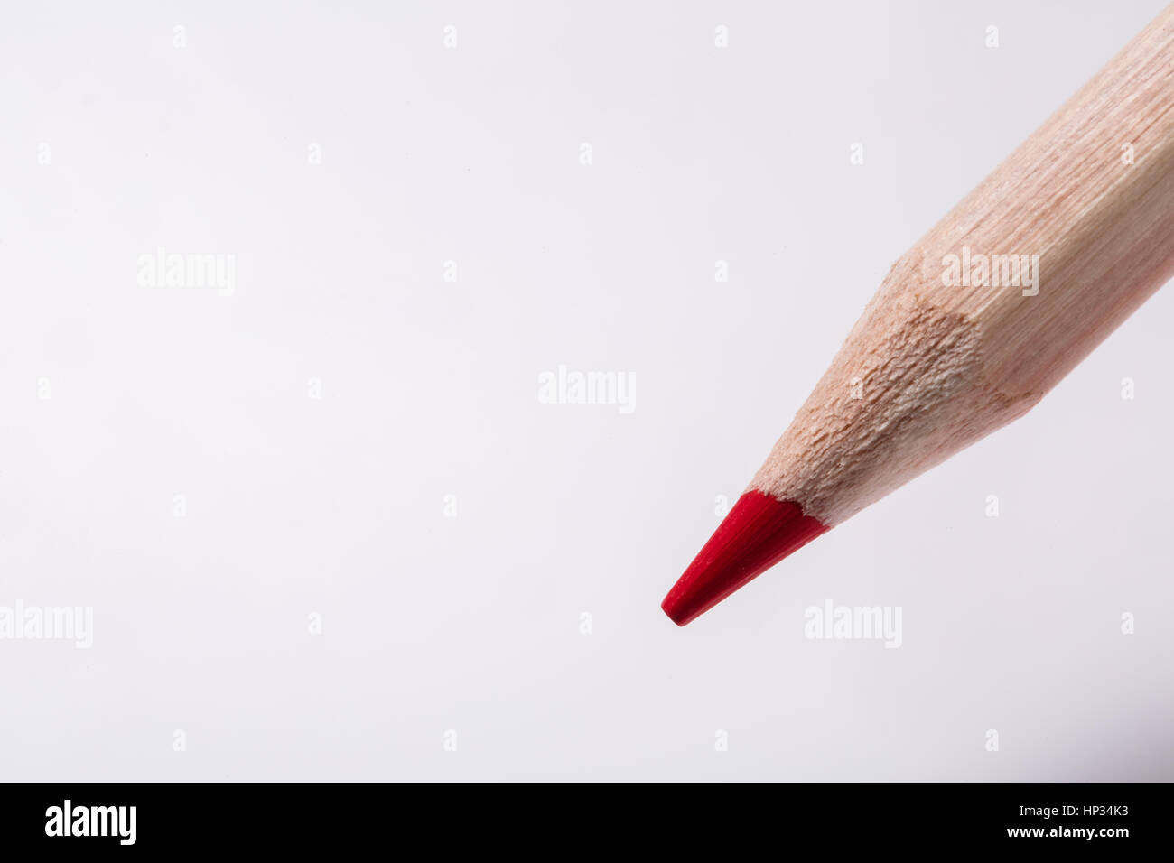red pencil draws or writing on white paper sheet. Sharpen pencil ...