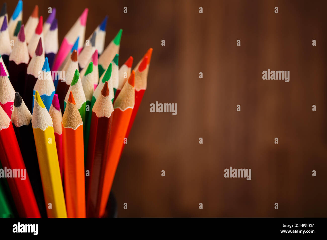 different pencils on the brown wooden table background. Colorful ...