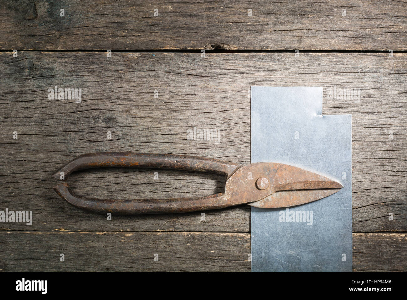 Old rusty scissors on metal on gray planks a background. Space for text ...