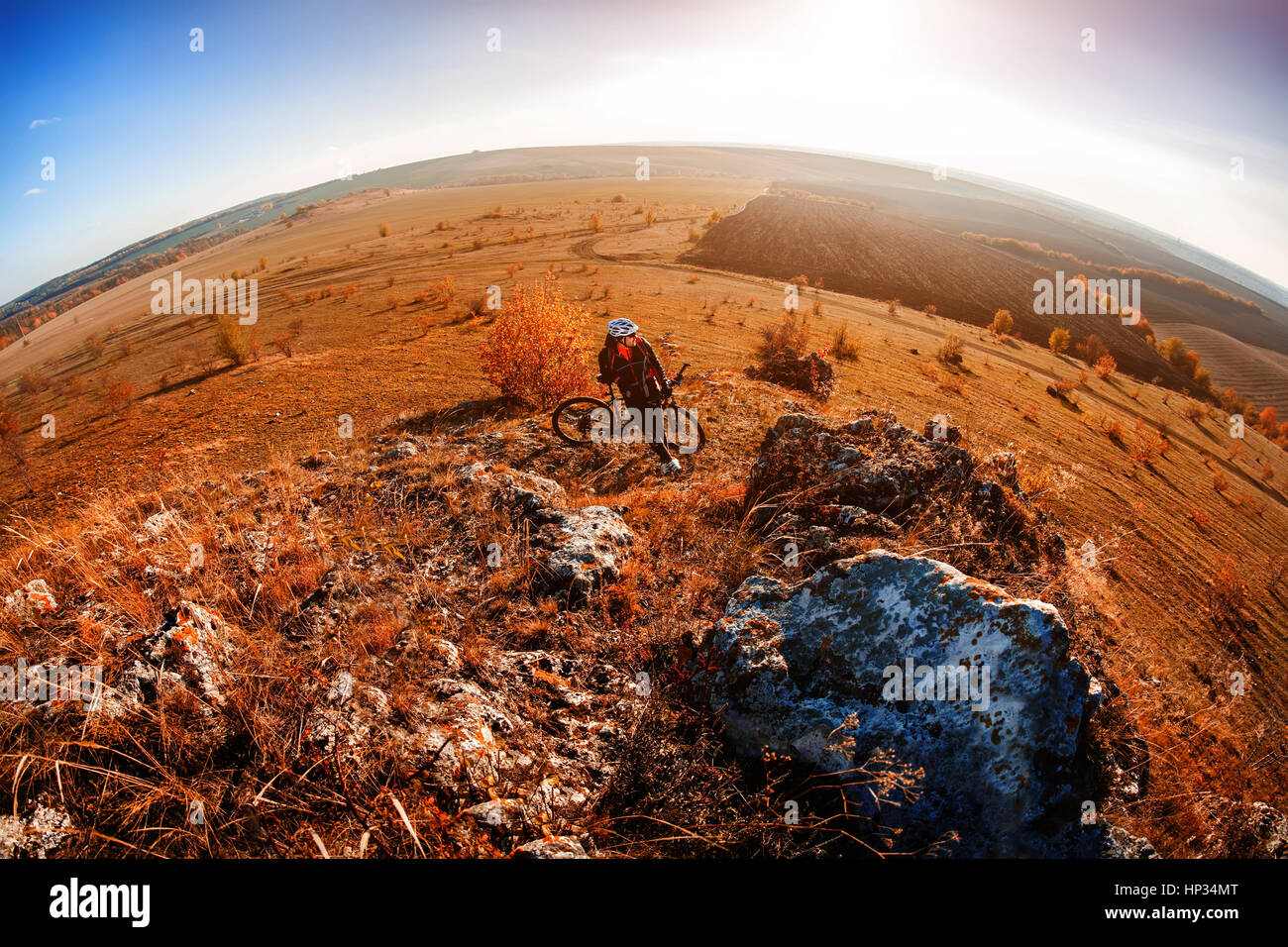 Wide angle view of cyclist standing with mountain bike on trail at ...
