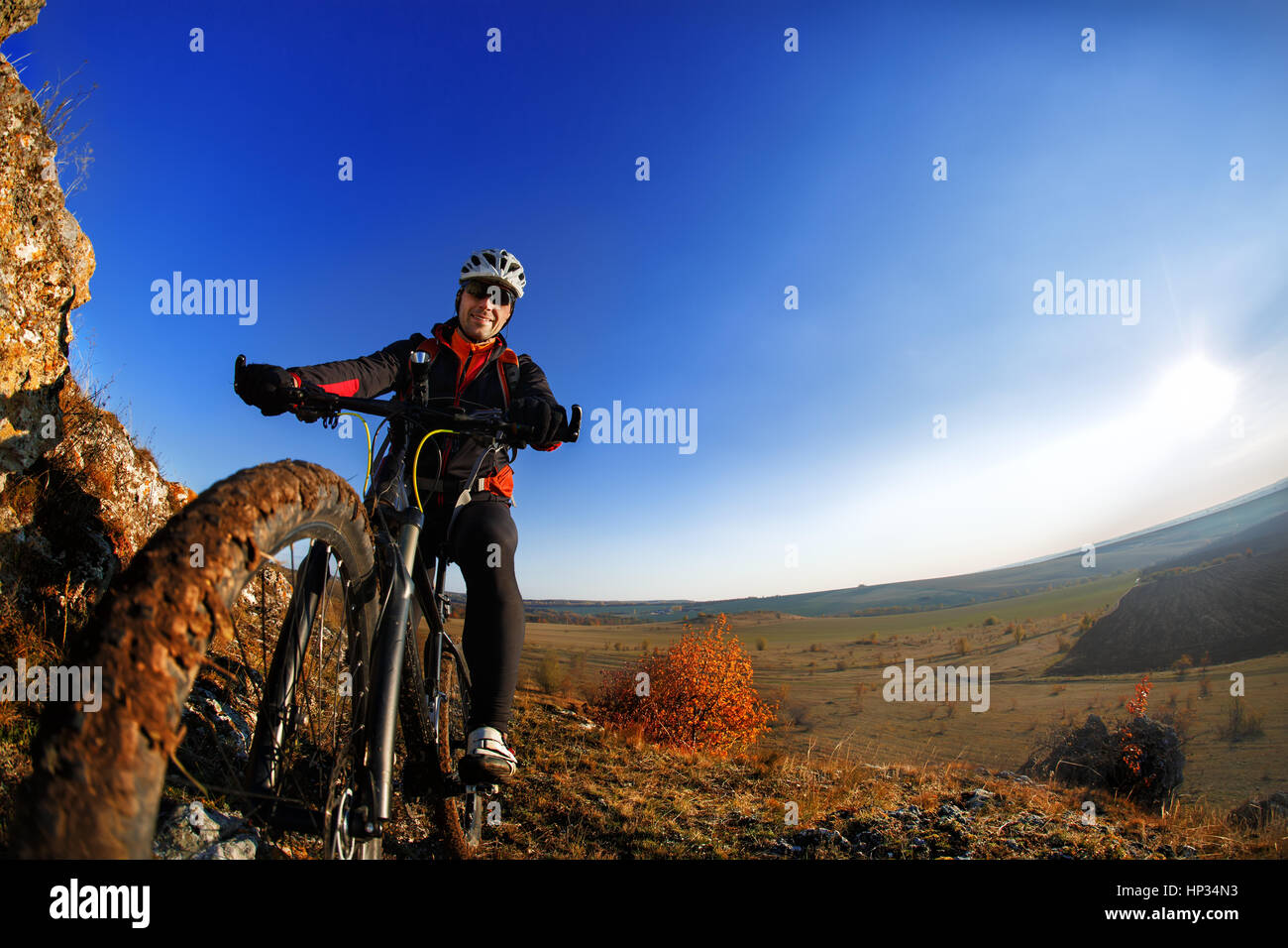 low angle view of cyclist riding mountain bike on rocky trail at ...