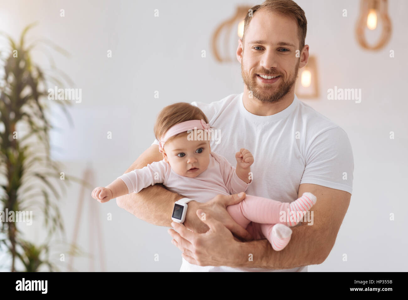 Positive father holding the child in his arms at home Stock Photo - Alamy