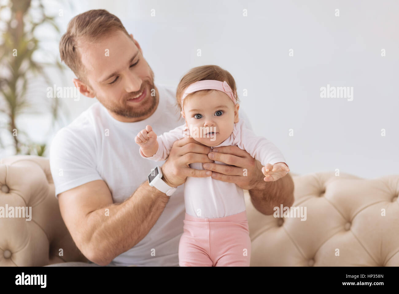 Delighted young man playing with his baby Stock Photo - Alamy