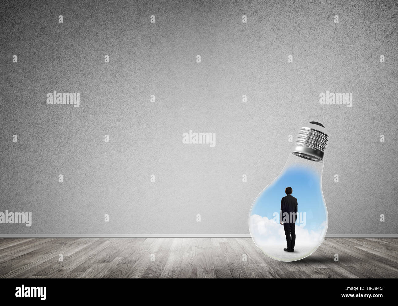 Businessman inside of light bulb in empty concrete room Stock Photo - Alamy