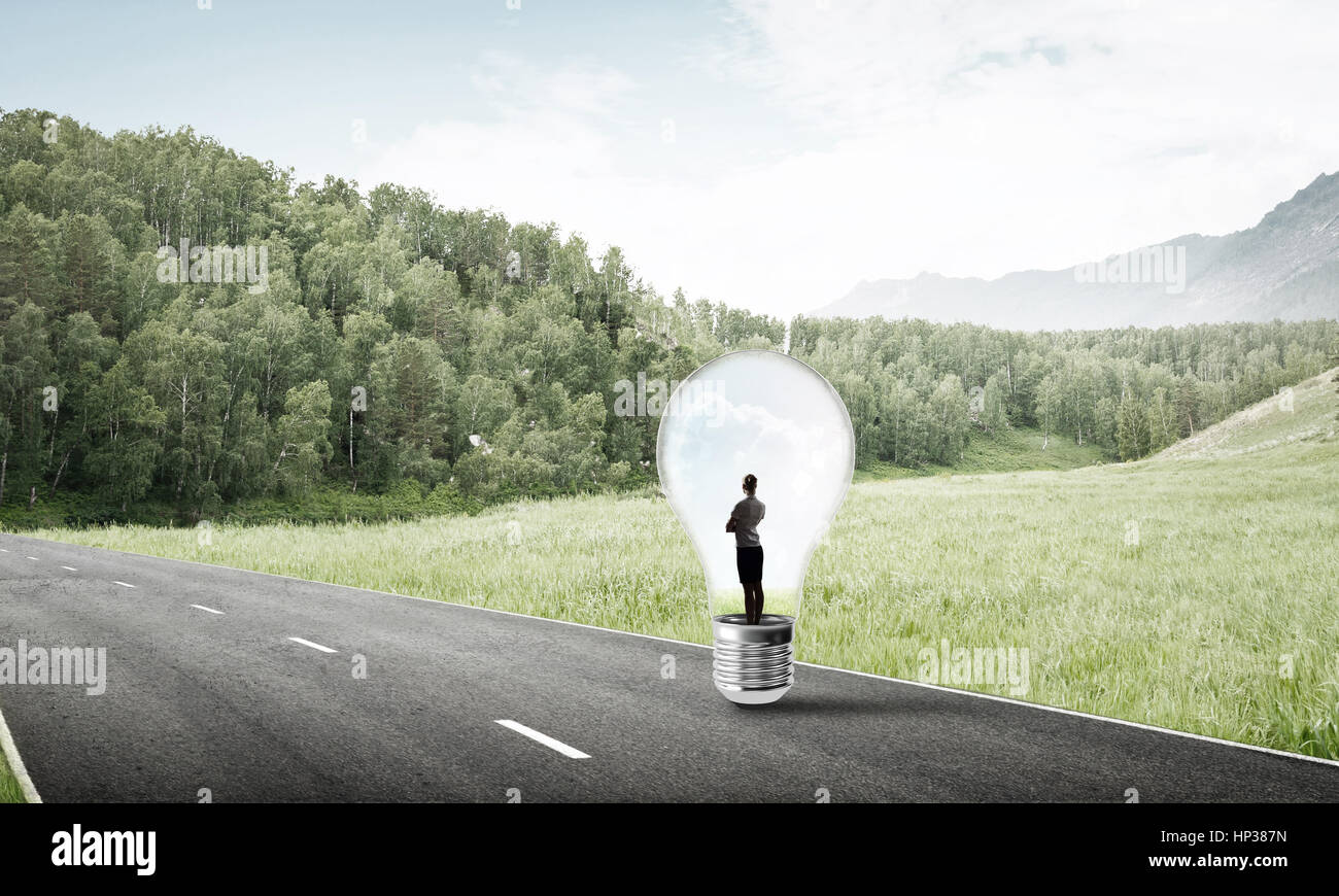Young businesswoman trapped inside of light bulb on asphalt road Stock ...