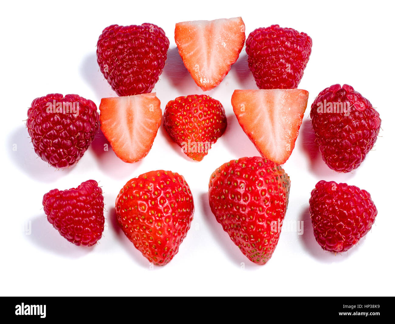 Chopped starwberries and raspberries making a pattern on a white ...