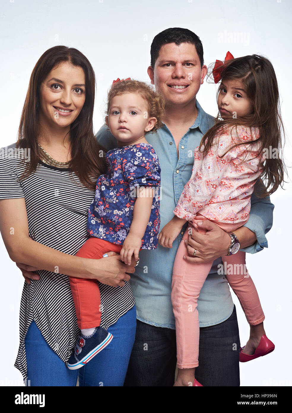 Happy young parents with two daughters kids isolated on white ...
