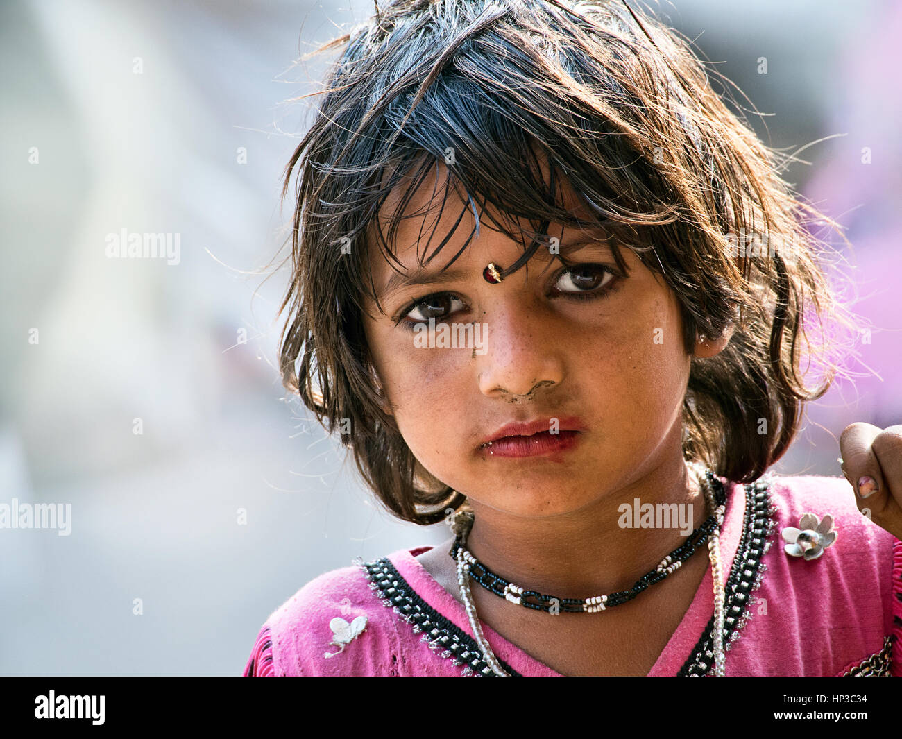 Portrait of an Indian female child with ruffled hair, lipstick done ...
