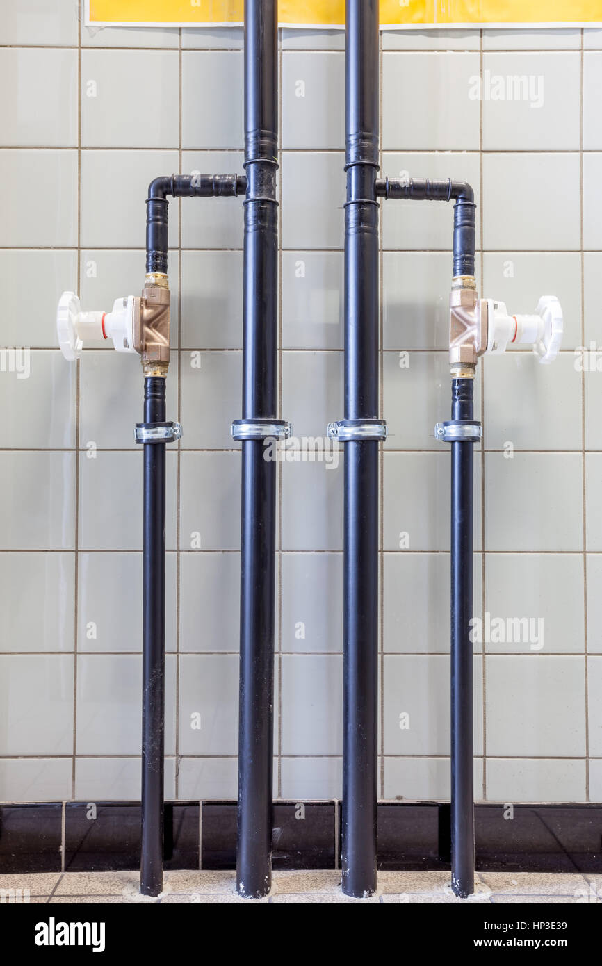 water pipes with valves on the wall Stock Photo - Alamy