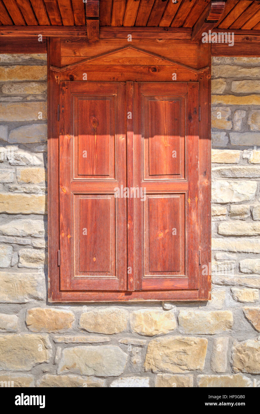 Stylish wooden windows on stone wall Stock Photo - Alamy