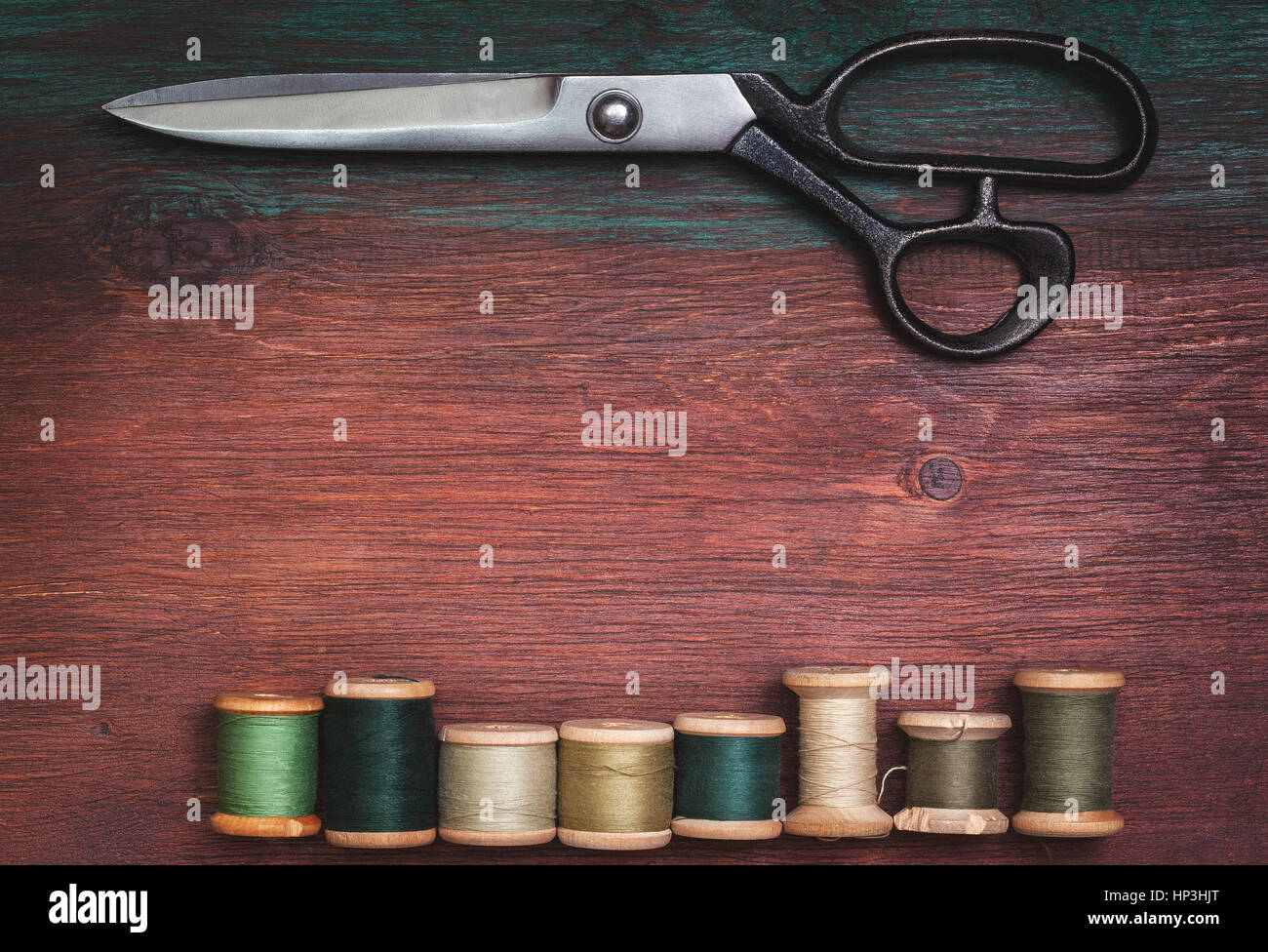 scissors and old threads on old wooden background in vintage style (top ...